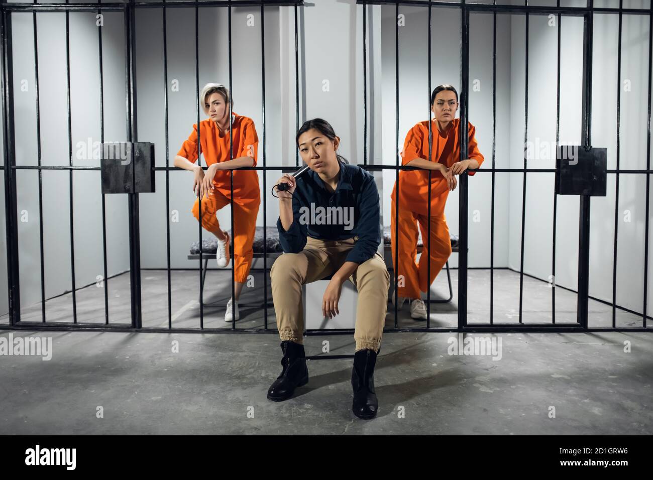 Three girls in a women's prison, a guard and two criminals pose for a ...