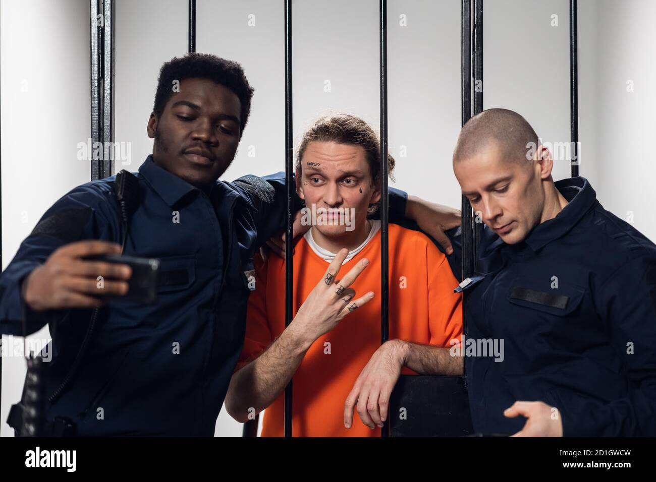 A prisoner with tattoos on his face takes a selfie with his fellow ...