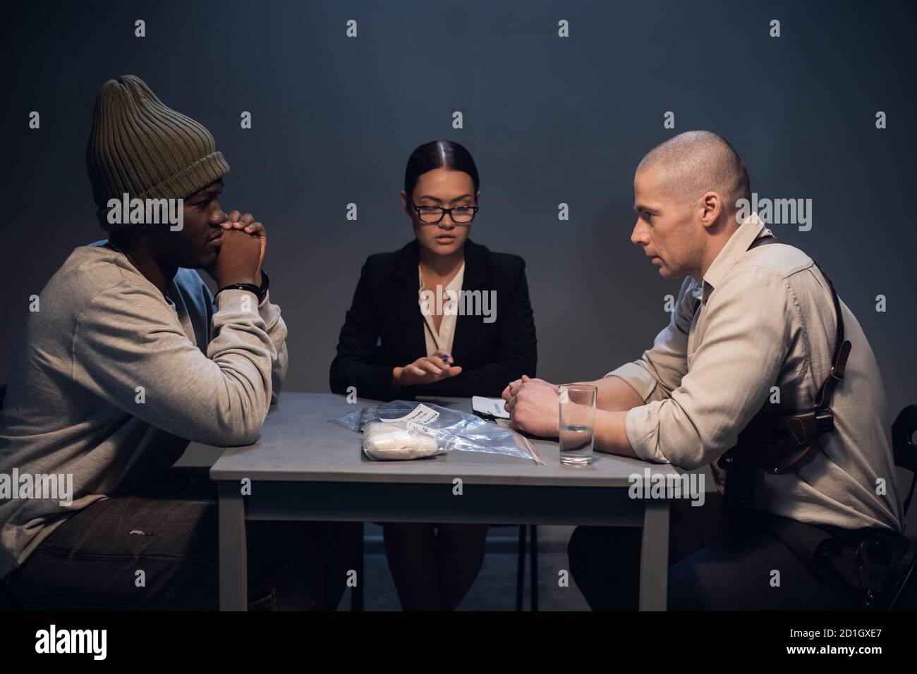 A black drug addict is interrogated at a police station by an ...