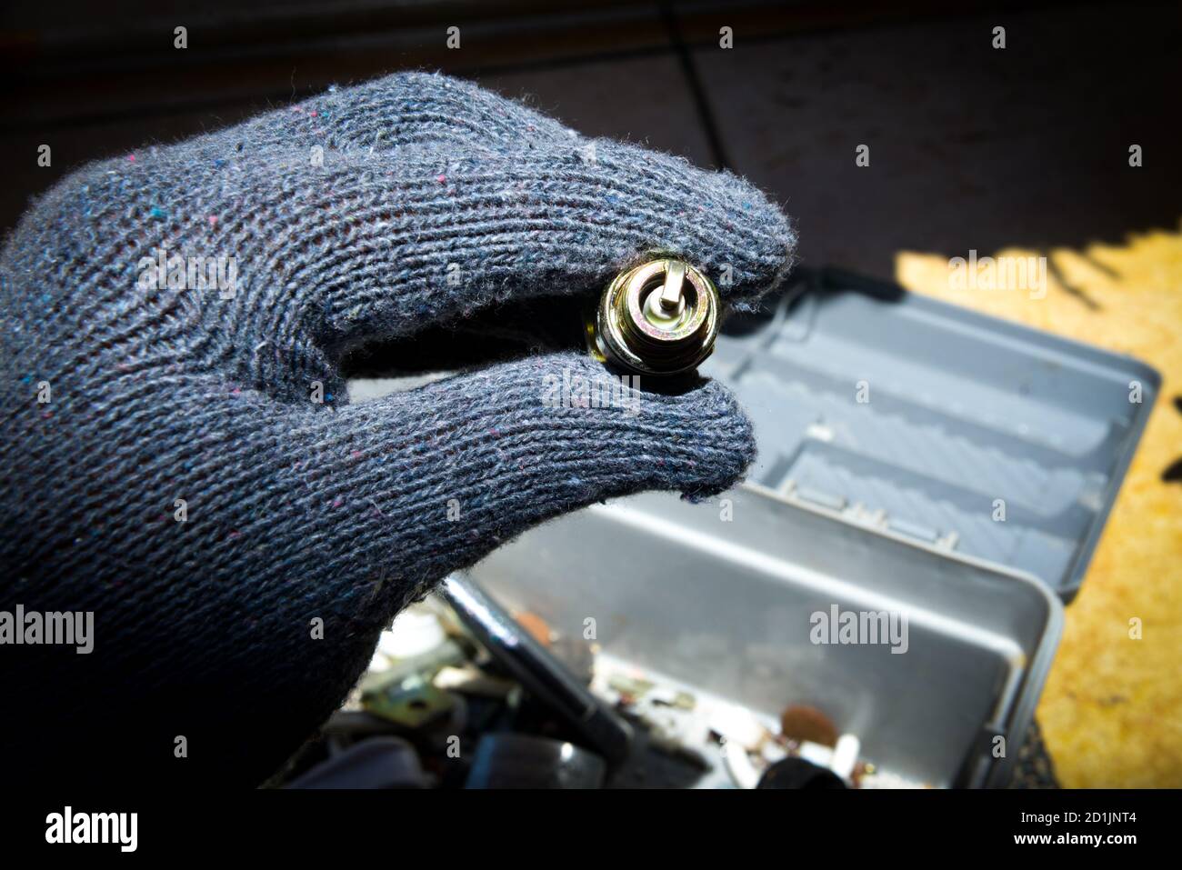 Hand with glove holding spark plug with blurred background Stock Photo ...