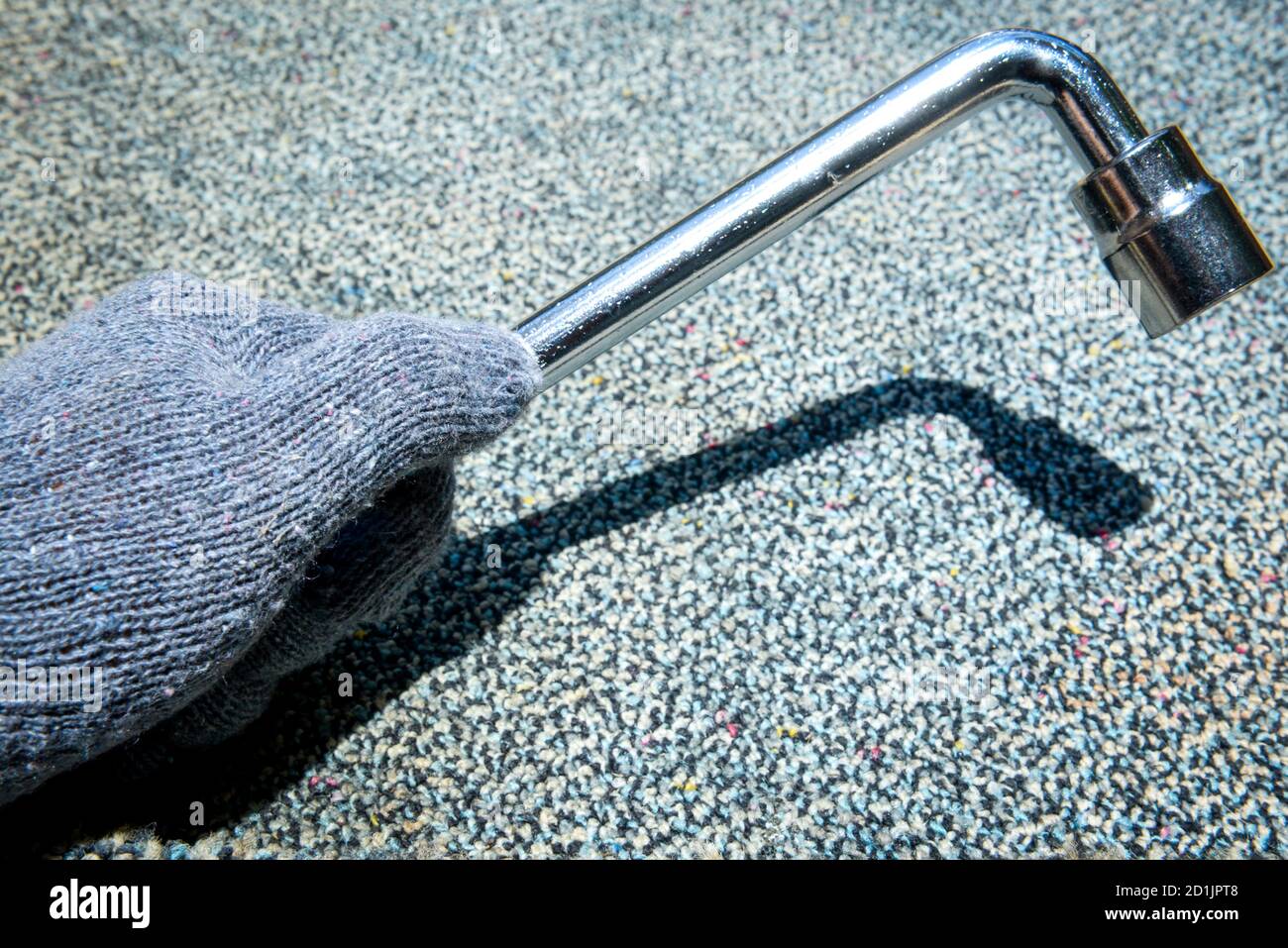 Hand with glove holding wrench handle with black background Stock Photo ...