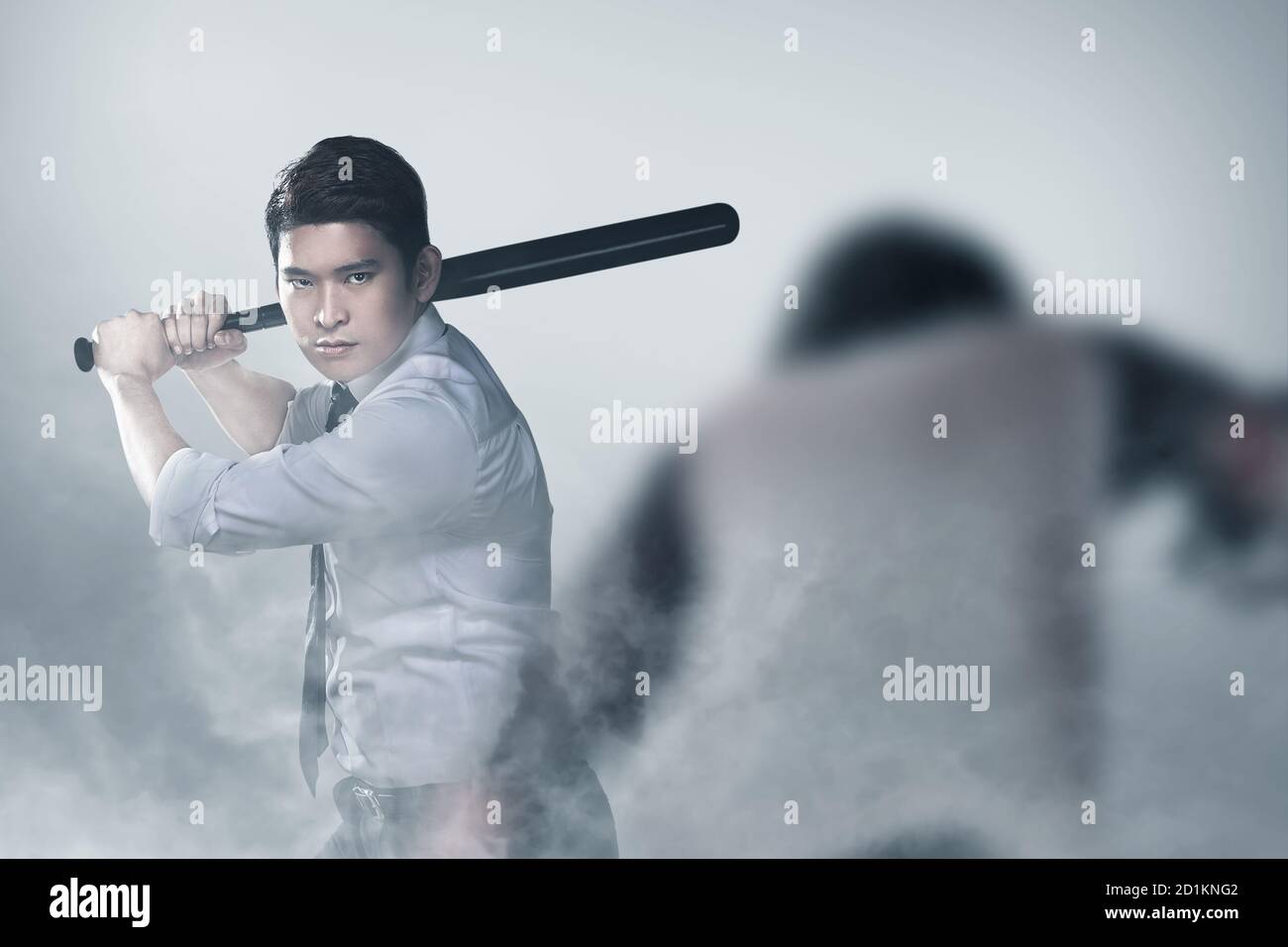 Asian man standing with a baseball bat in his hand ready to attack ...