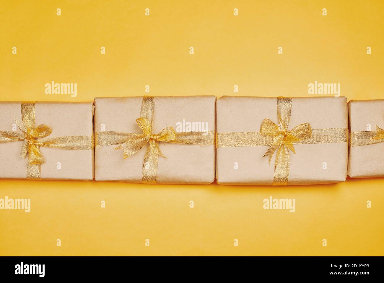 Row of Christmas present boxes on yellow background. Christmas gifts ...