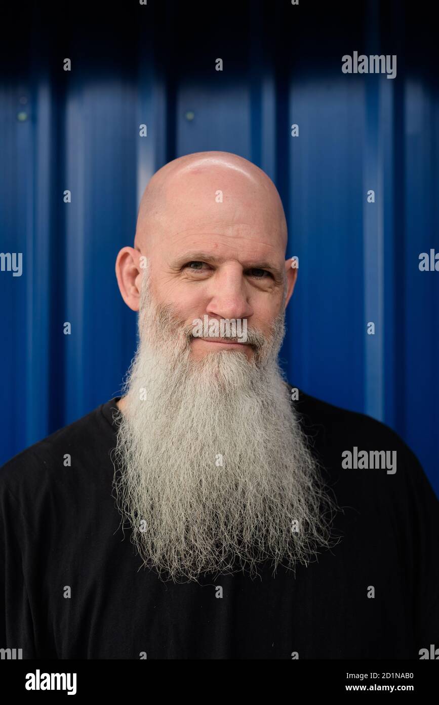 Face of mature handsome bald bearded man against metal sheet wall Stock ...