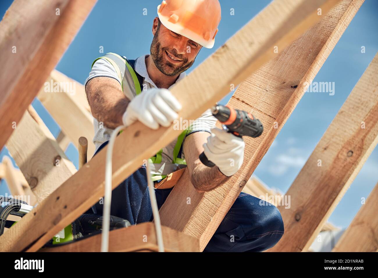 Positive delighted bearded man fixing crews into board Stock Photo - Alamy