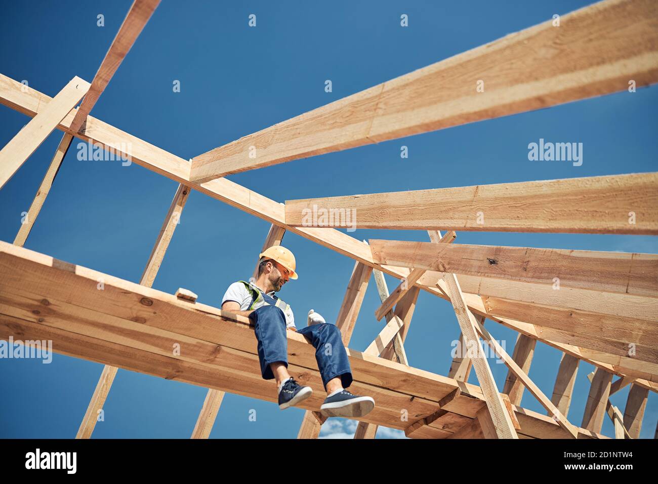 Brave builder sitting high on the beams Stock Photo - Alamy
