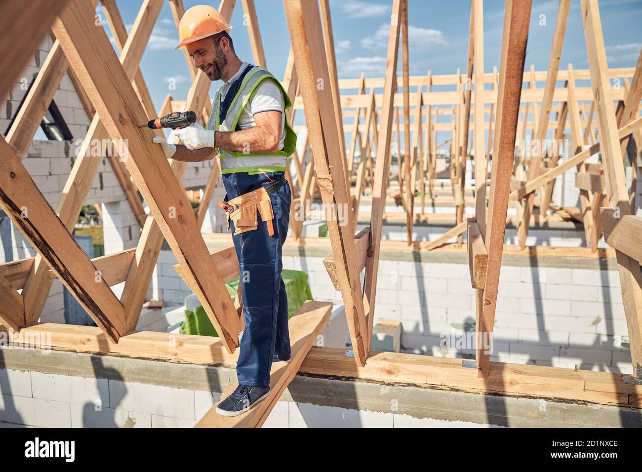 Cheerful male person working on building of his house Stock Photo - Alamy