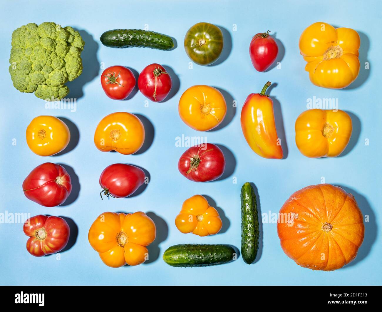 Different fresh farm vegetables laid out on blue background. Top view ...