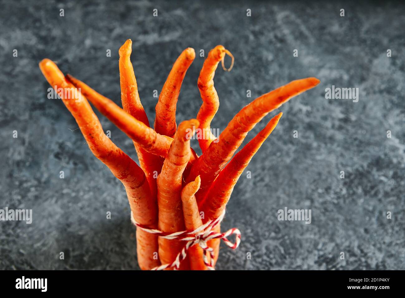 Ugly food. Deformed organic carrots on a blue background. Deformed ...