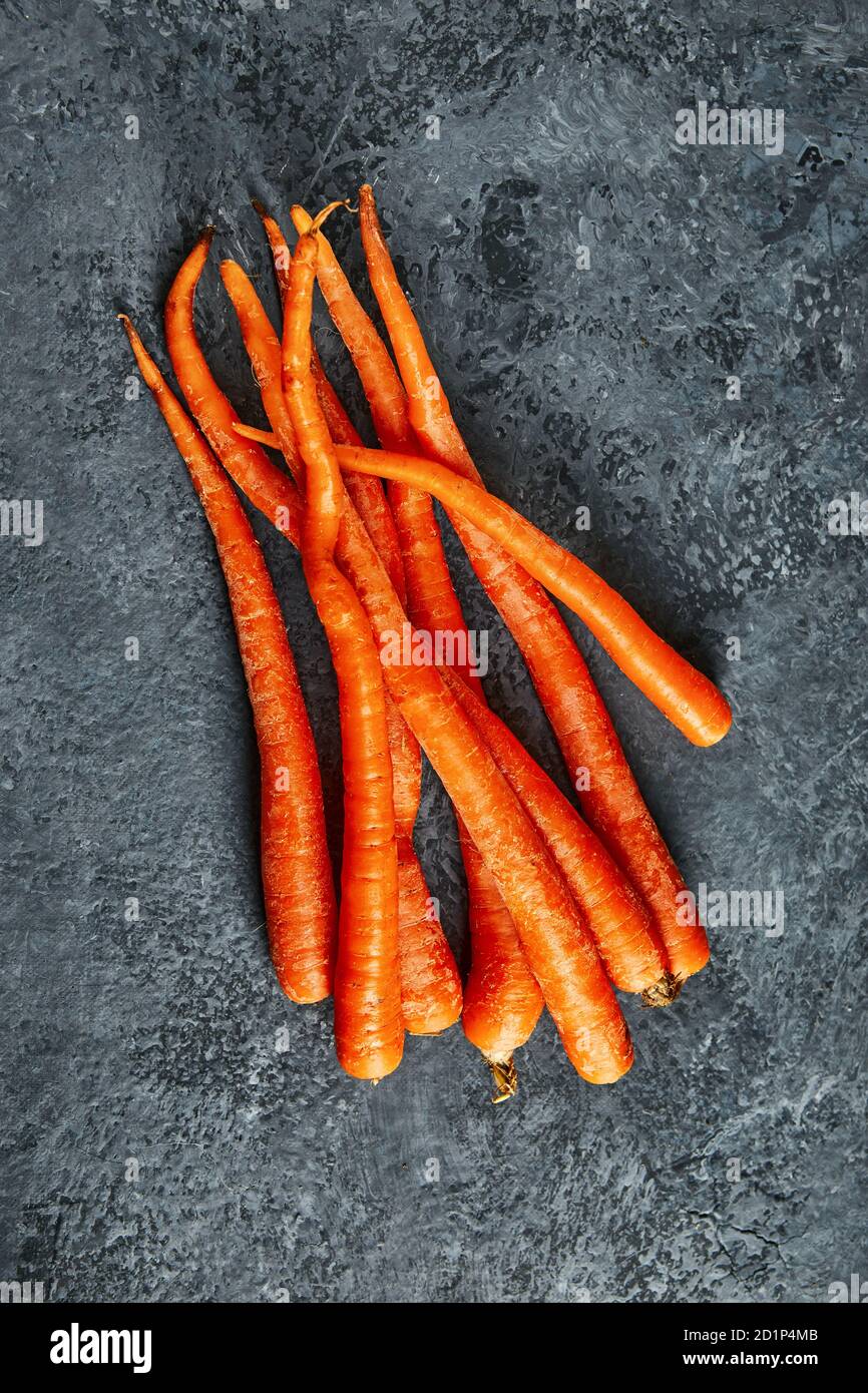 Ugly food. Deformed organic carrots on a blue background. Deformed ...