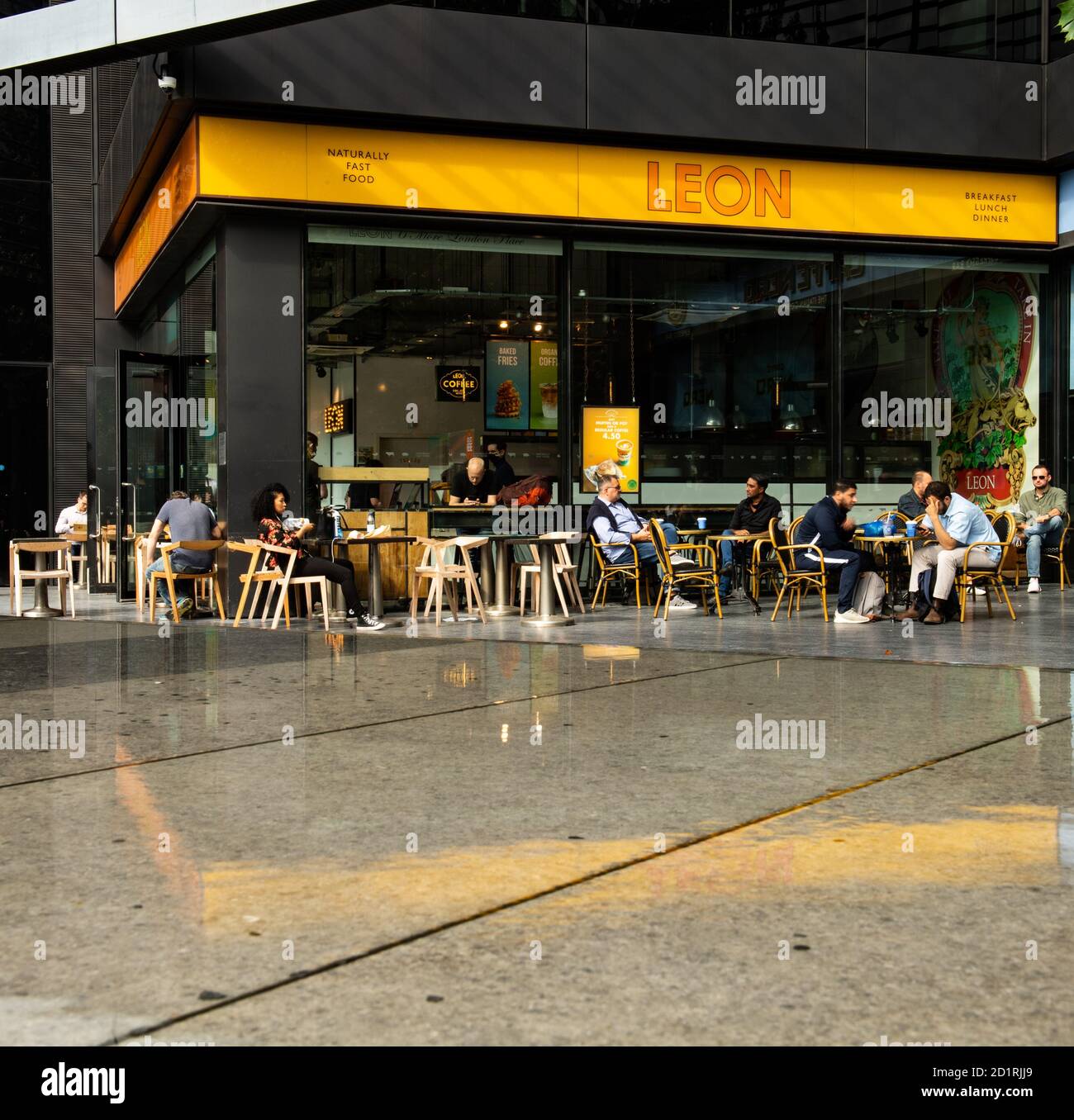 People sit outside the exterior of a Leon food retail chain cafe in ...