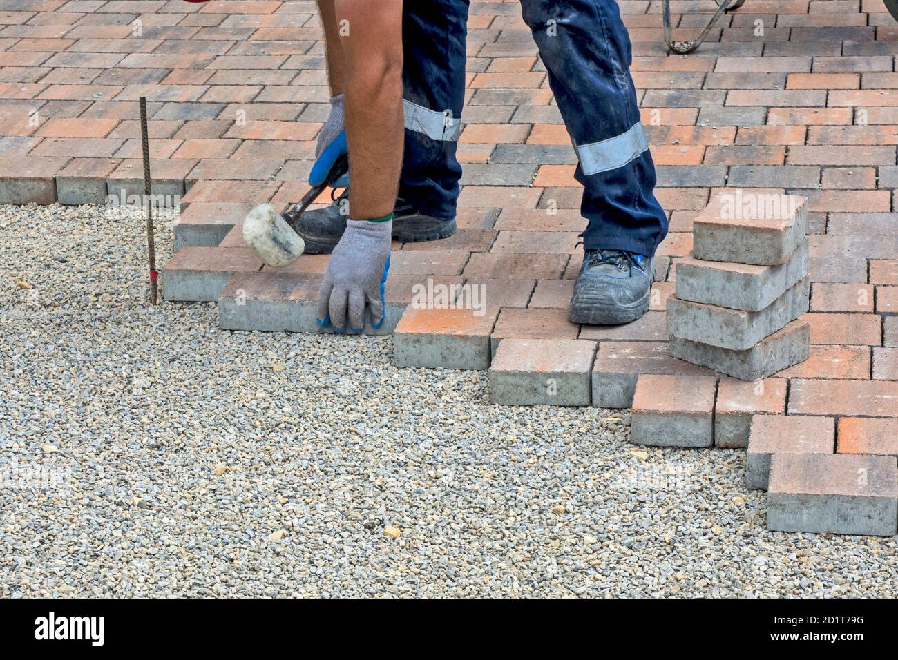 Master lay and install floor bricks on a public surface. The base is ...
