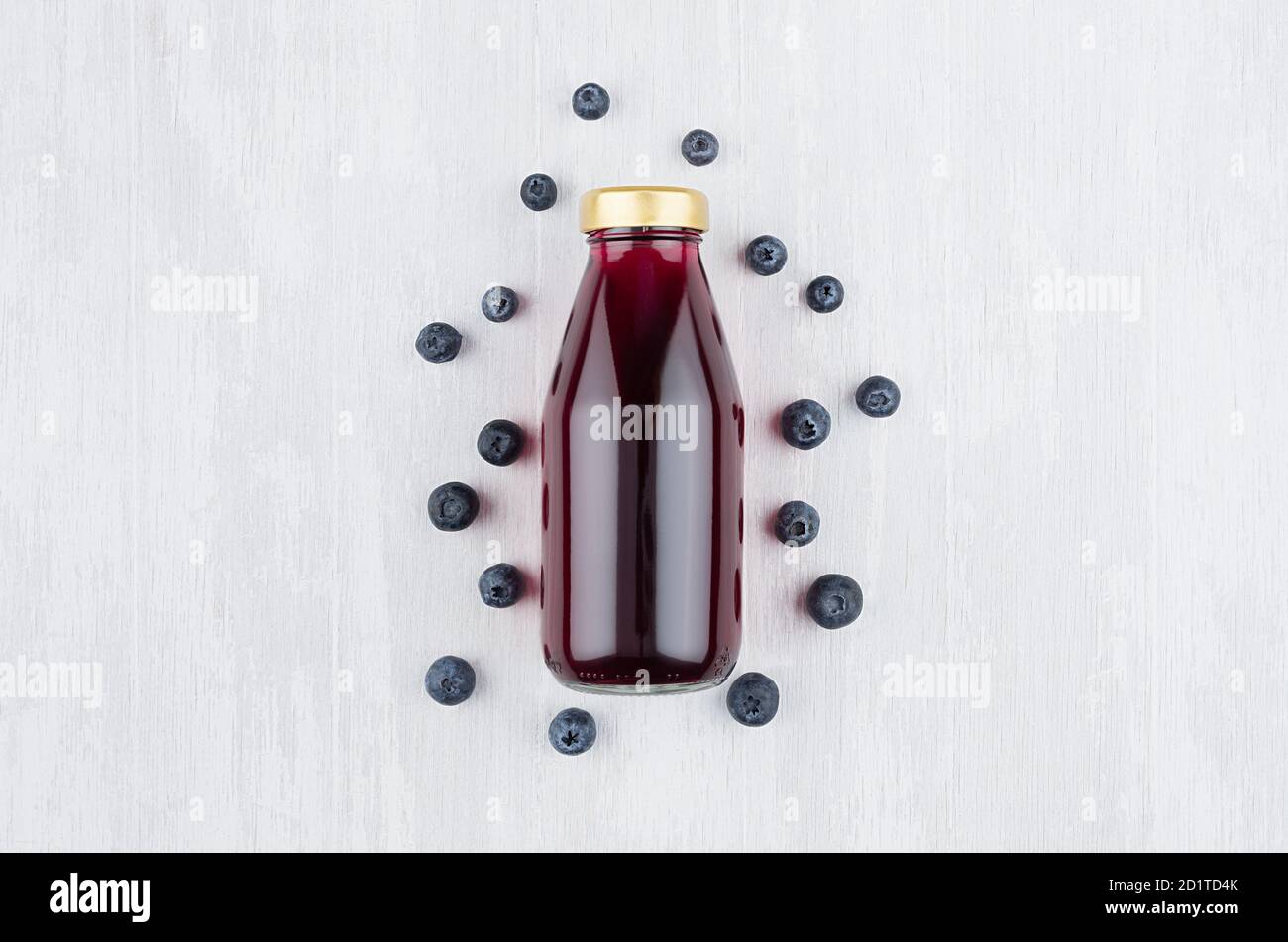 Organic transparent purple blueberries juice in glass bottle with ...