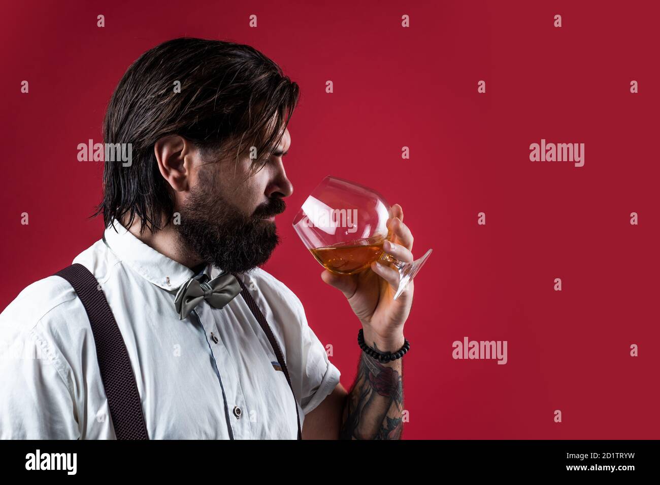 handsome hipster drinking rum glass. party goer with alcohol. brandy or ...