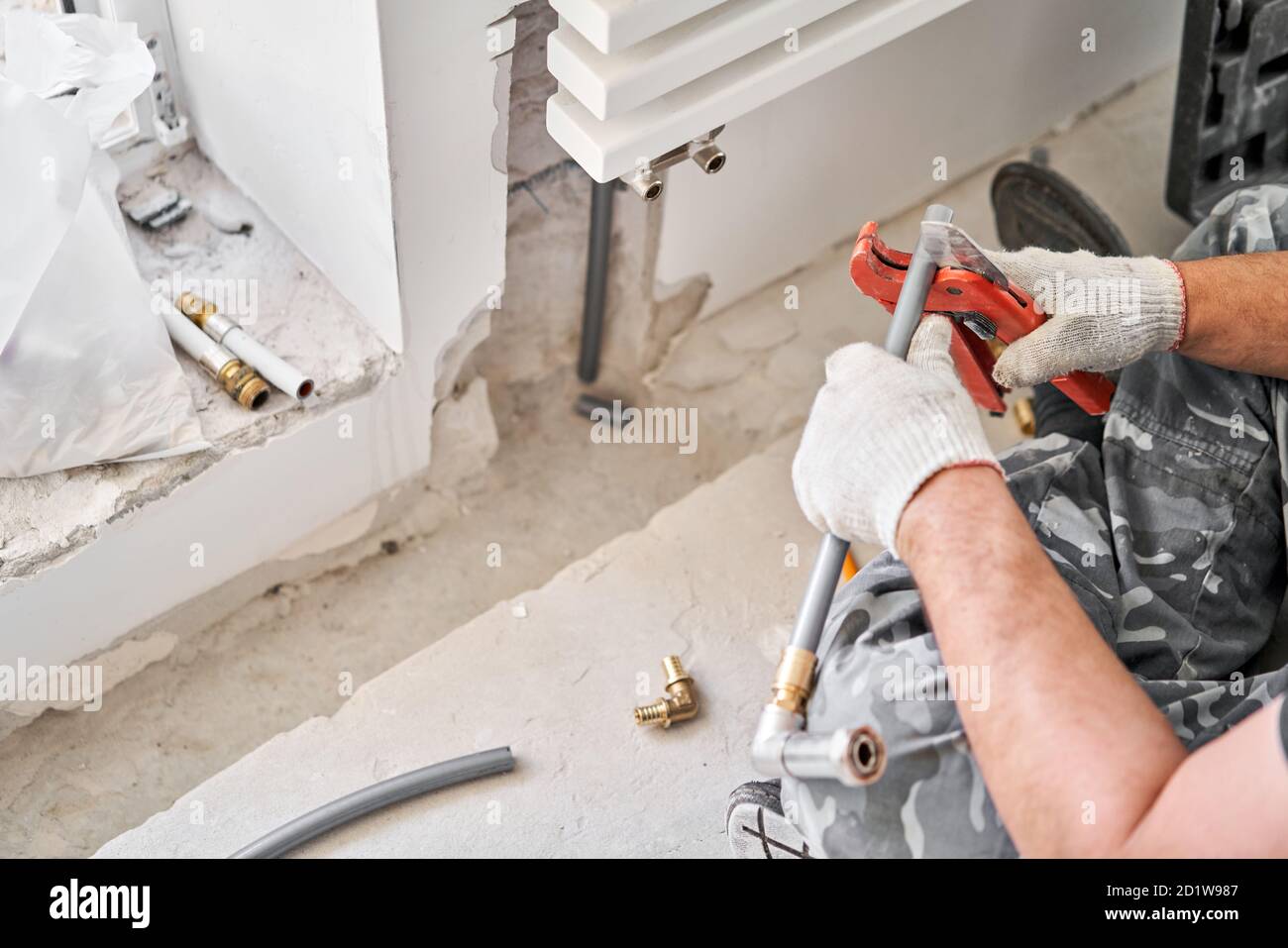Plumber cuts the desired length of pipe with scissors tool. connection ...