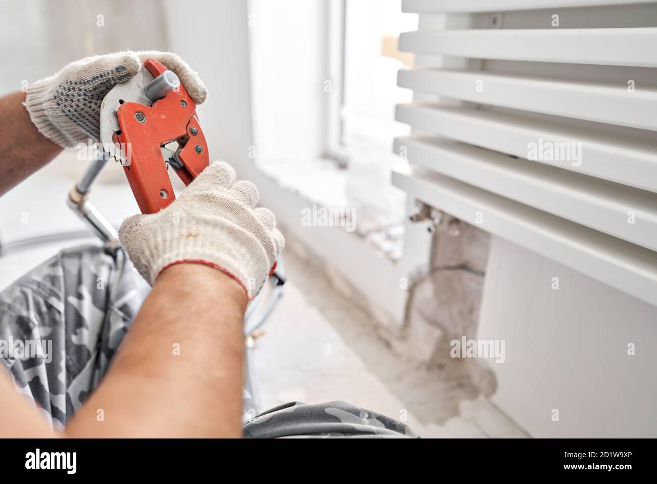 Plumber cuts the desired length of pipe with scissors tool. connection ...