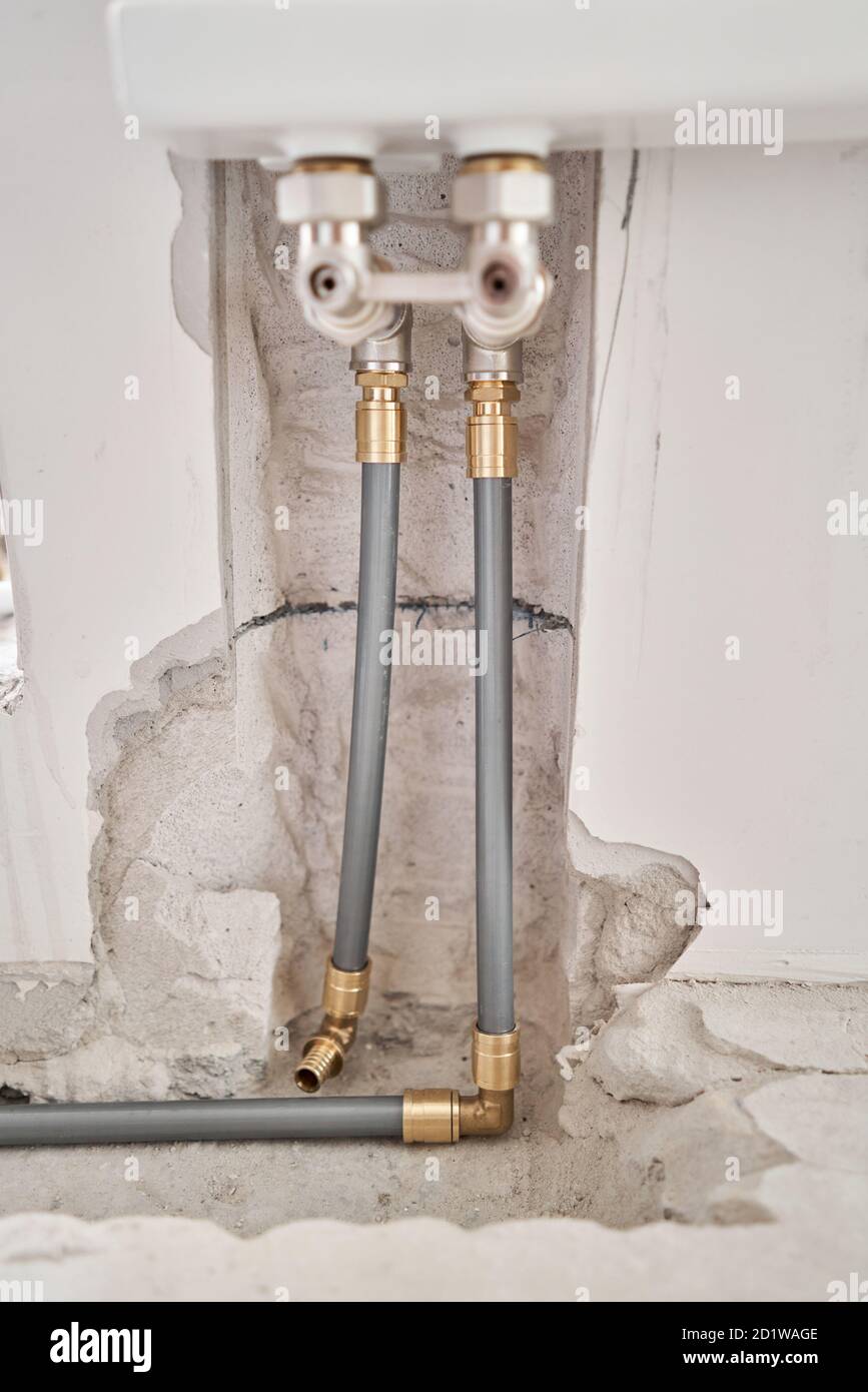 connection heating pipes to white Radiator in a new apartment under ...