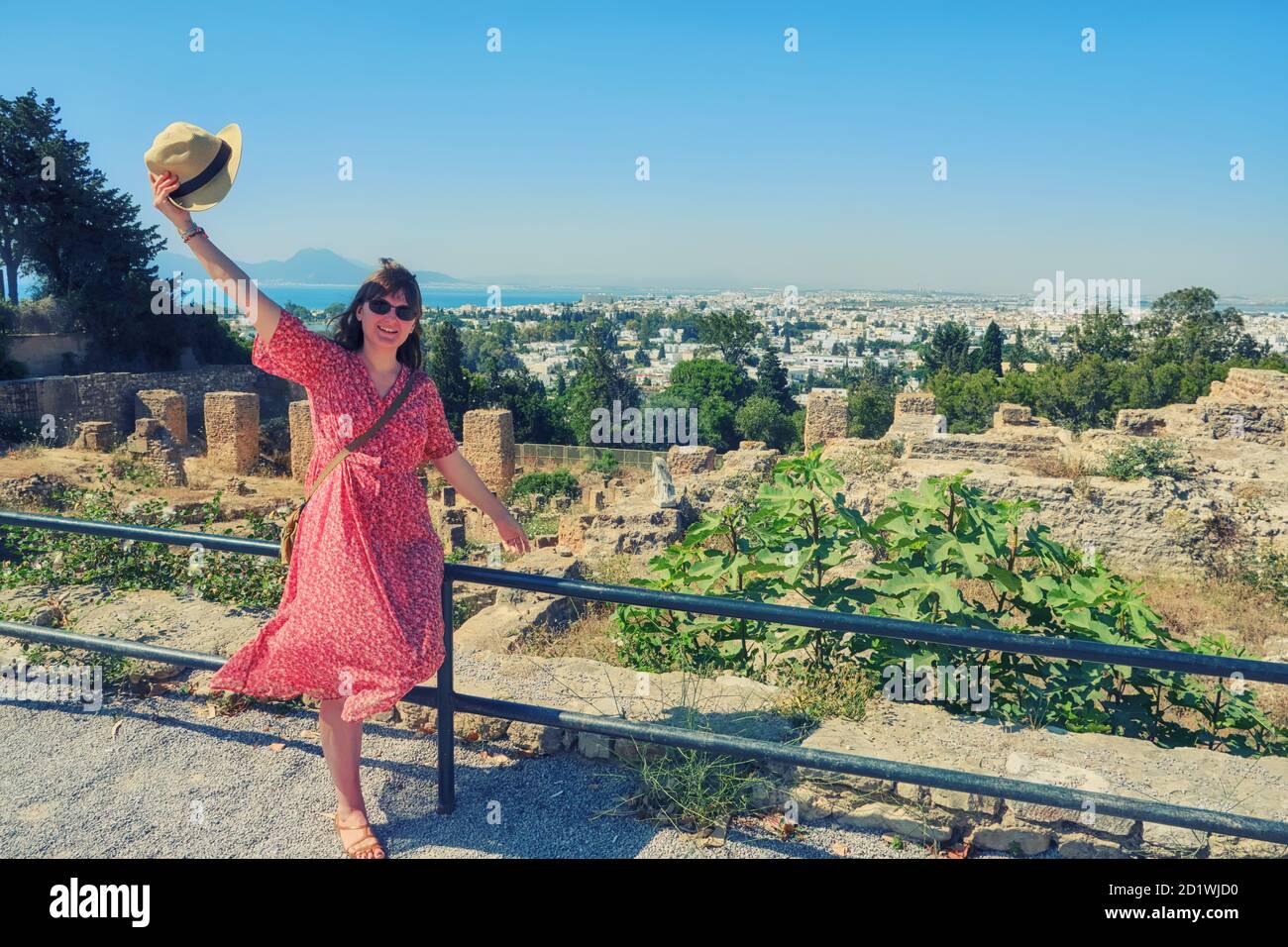 A young woman near the excavations of the ruins of Roman buildings in ...