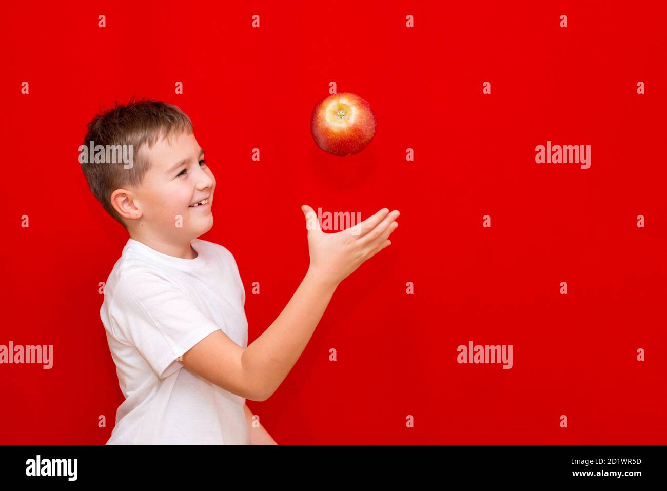 Side view Close up European boy kid child schoolboy throw up apple ...