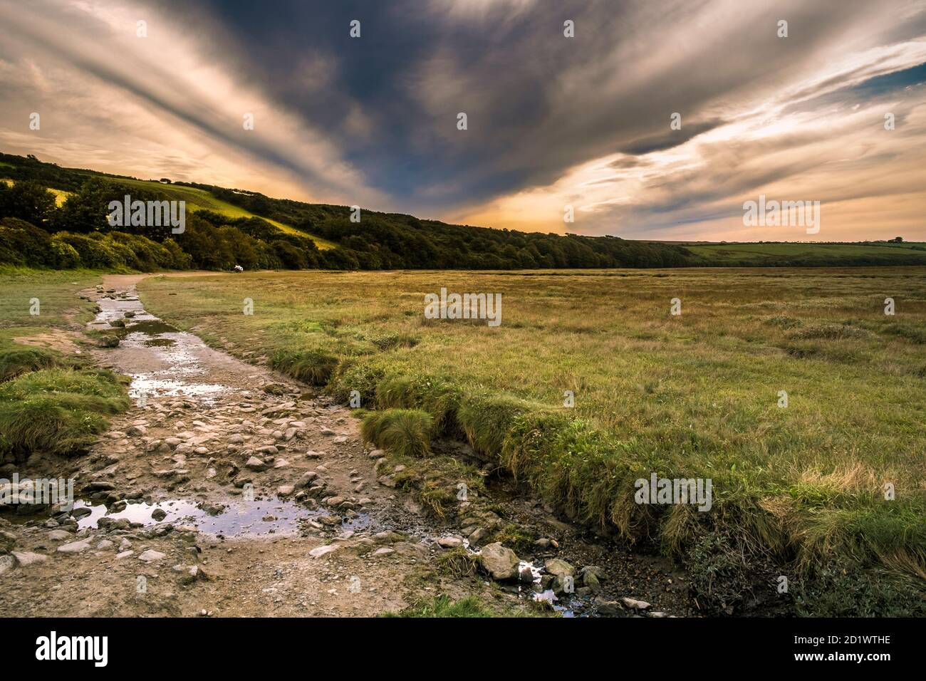 Early evening sunlight over the River Gannel at low tide in Newquay in ...