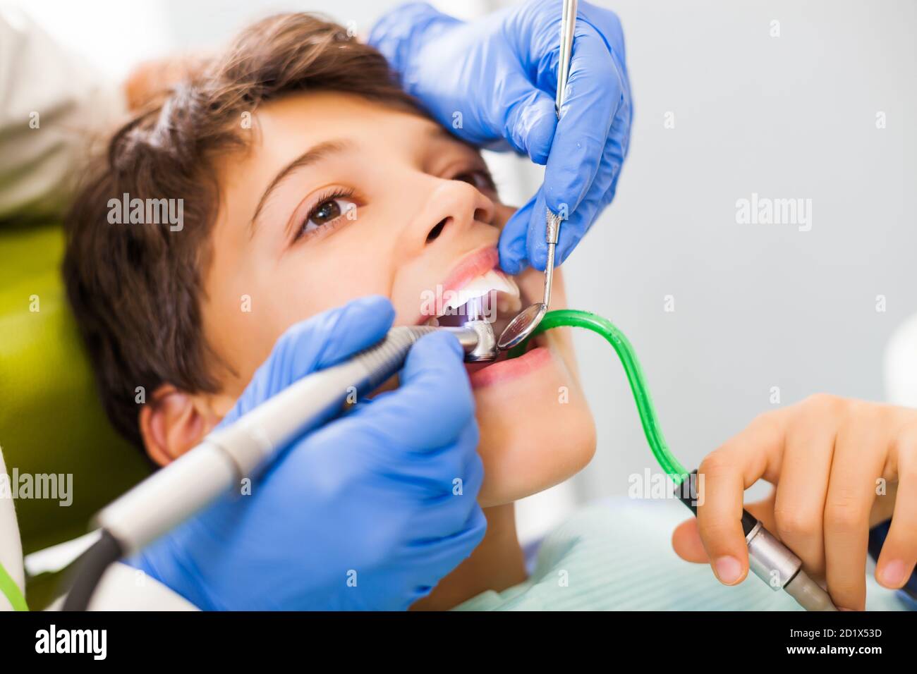Dentist is repairing teeth of a young boy Stock Photo - Alamy