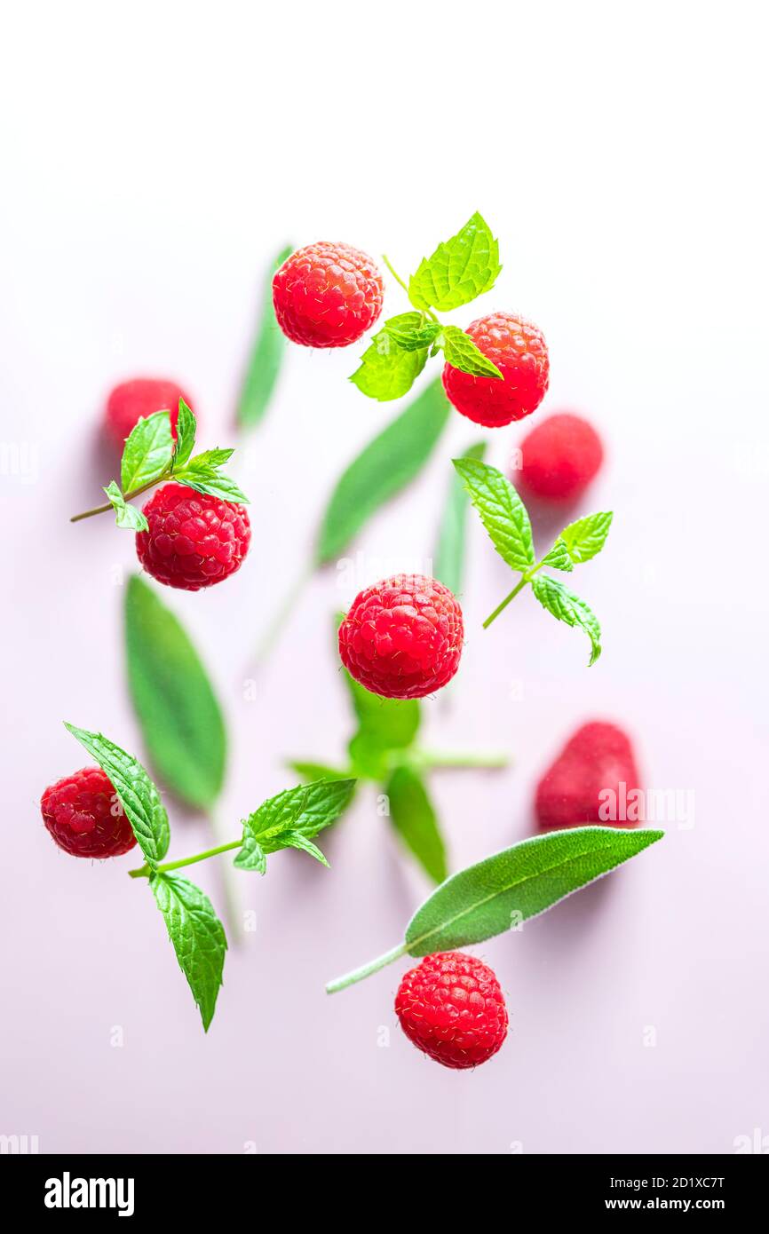 Concept of food levitation. Fresh ripe raspberry fruits and blueberries ...