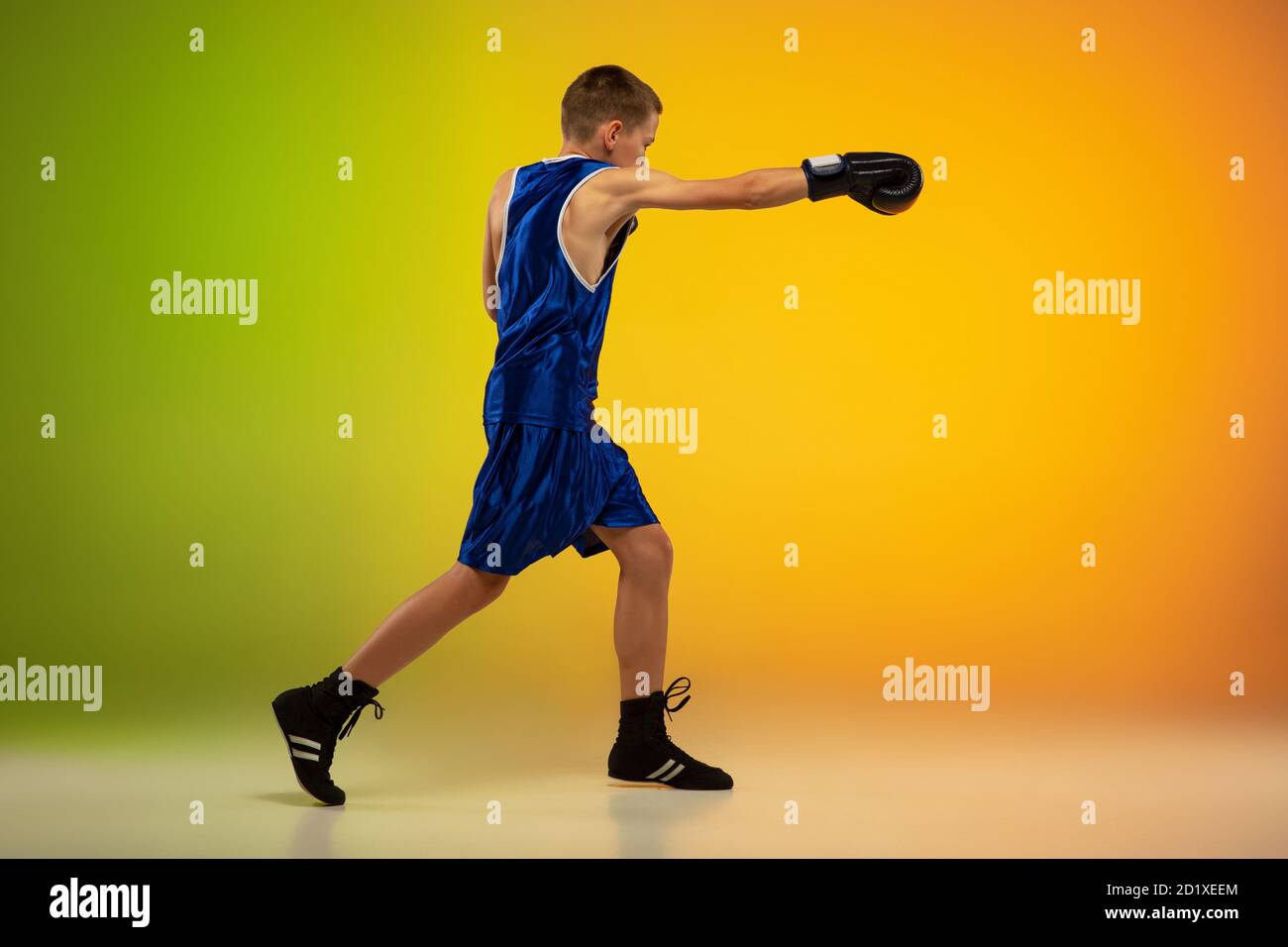 Stronger. Teenage professional boxer training in action, motion ...