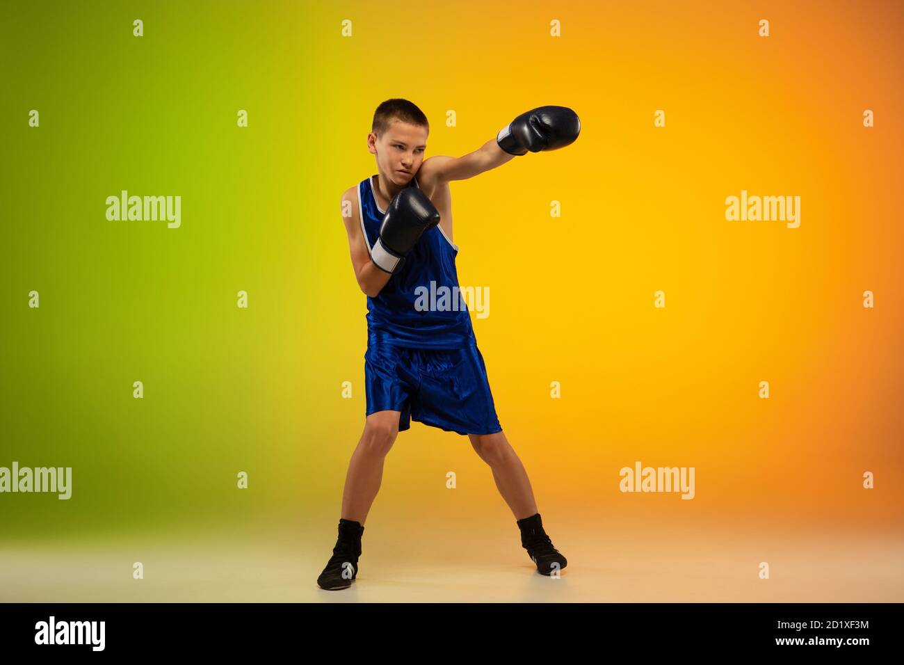 Stronger. Teenage professional boxer training in action, motion ...