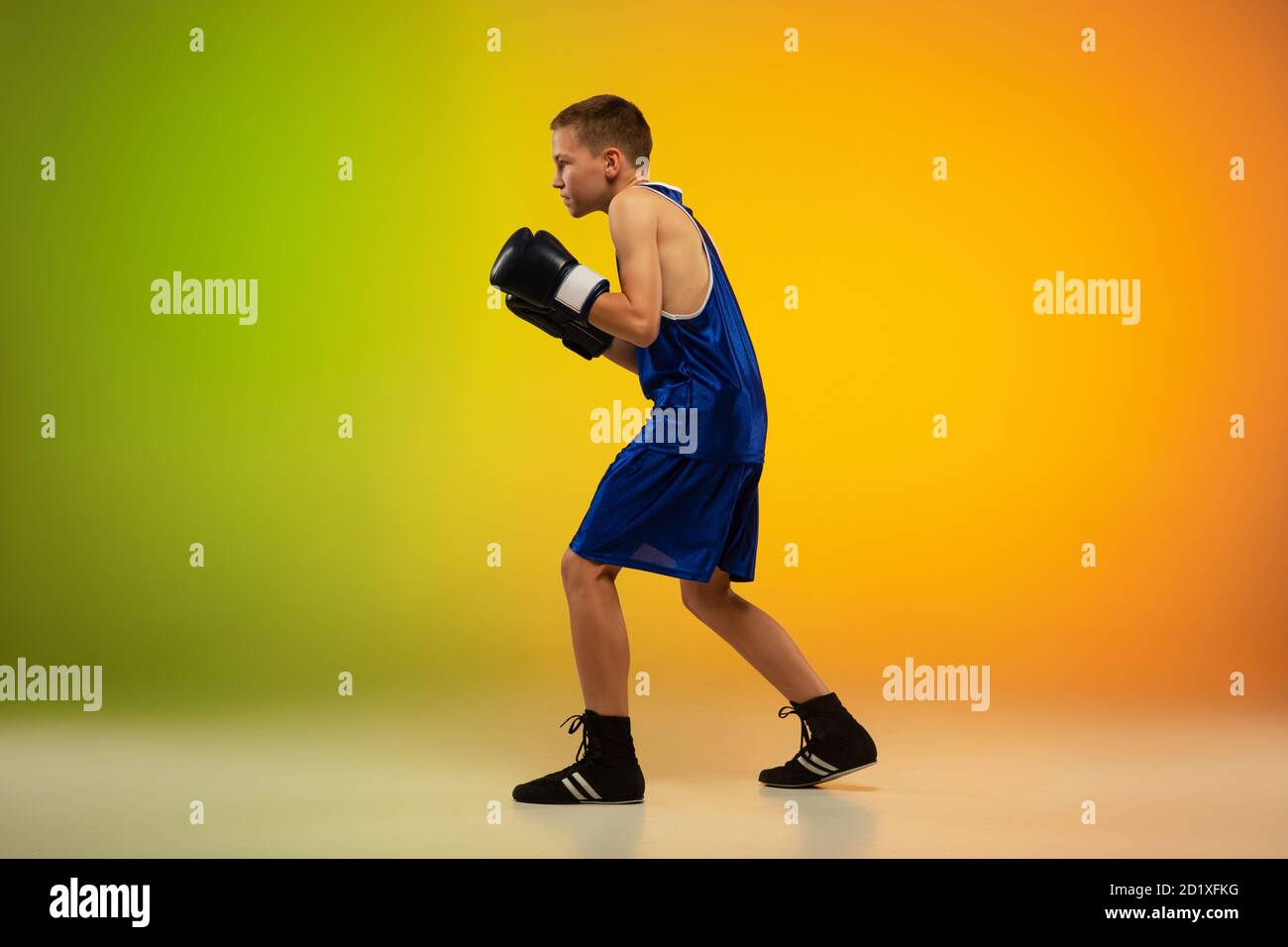 Stronger. Teenage professional boxer training in action, motion ...