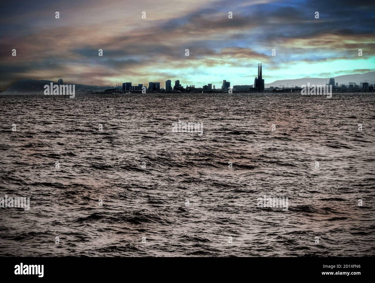 Dramatic cloudscape over wavy seawater with a skyline of a city on the ...