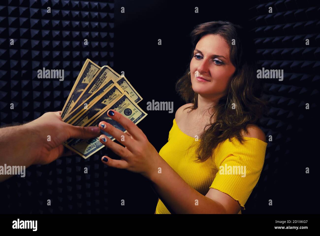 A young woman smiles getting money for work in a recording Studio. The ...