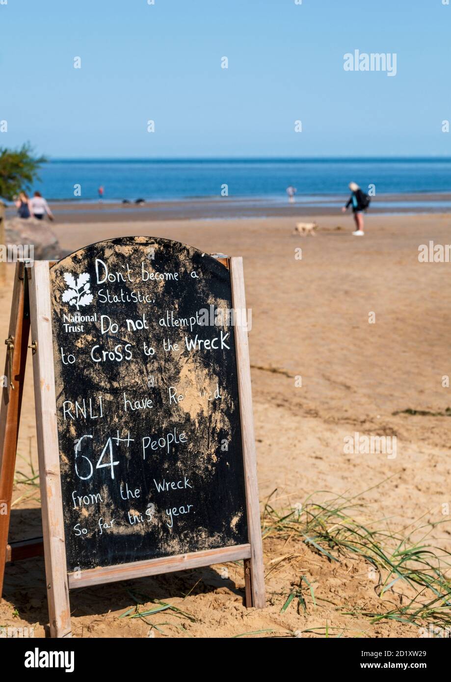 Sign on Brancaster beach warning against crossing to the wreck Stock ...
