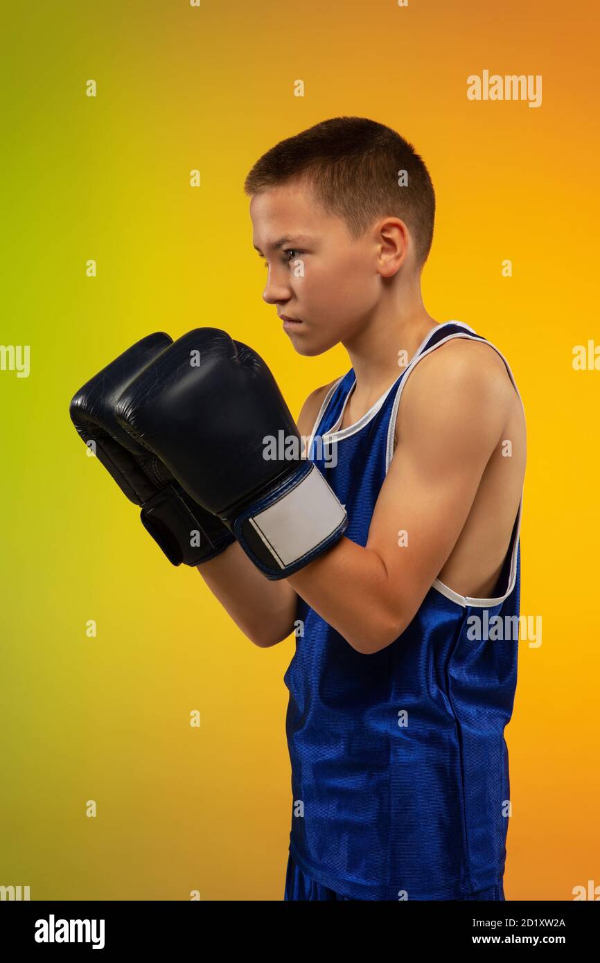 Angry. Teenage professional boxer training in action, motion isolated ...