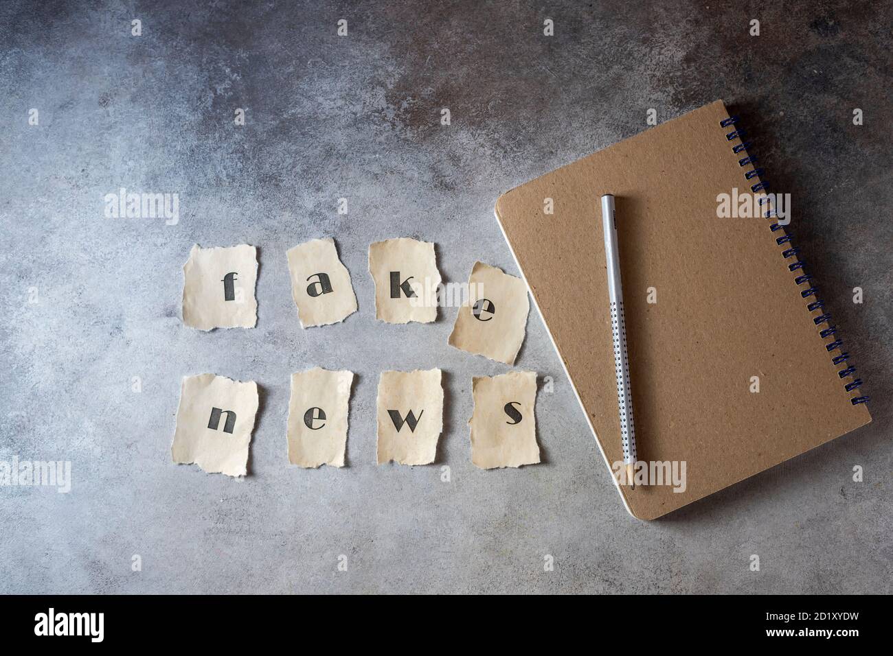 Fake news concept, letters written on old paper, on gray concrete ...
