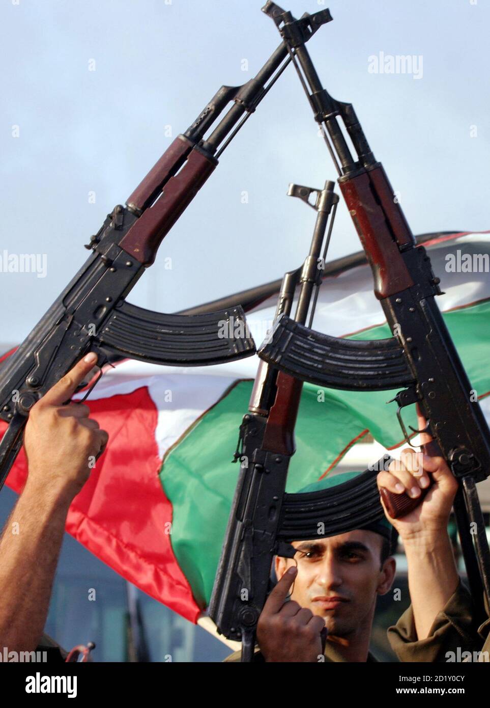 Palestinian security forces raise their weapons as they celebrate their ...