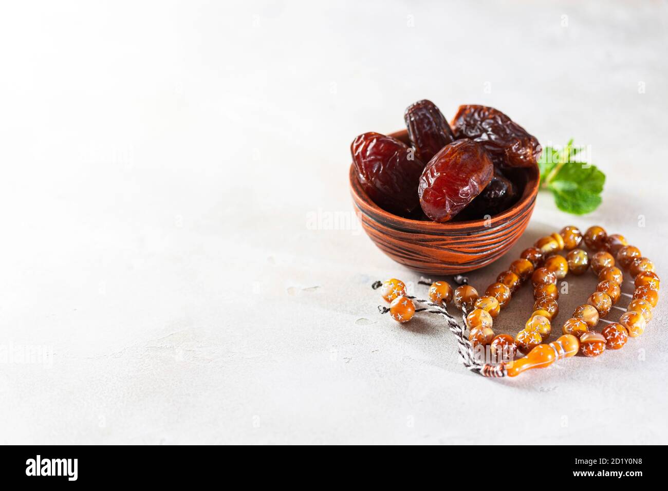 Plate with dates, decorative arabic lantern and rosary on a light ...