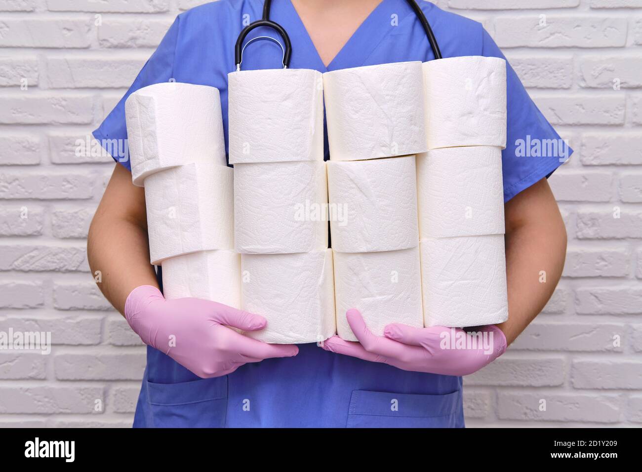 Doctor with rolls of toilet paper in his hands. A nurse holds a lot of ...