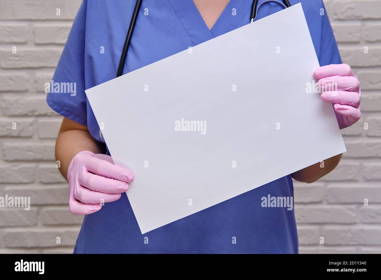 Doctor holds an empty blank sheet of paper, copy space for the ...