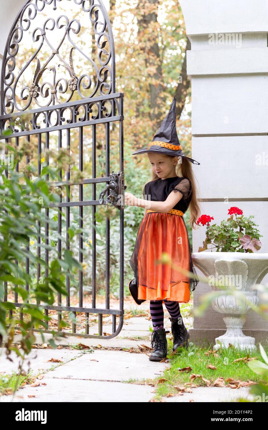 Happy little girl wearing a witch carnival costume and basket for ...