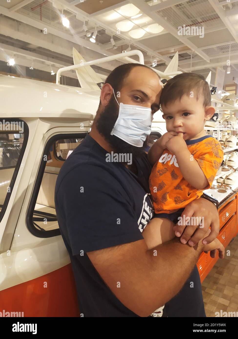 Dad wearing a face mask and holding his cute lovely son - the new ...
