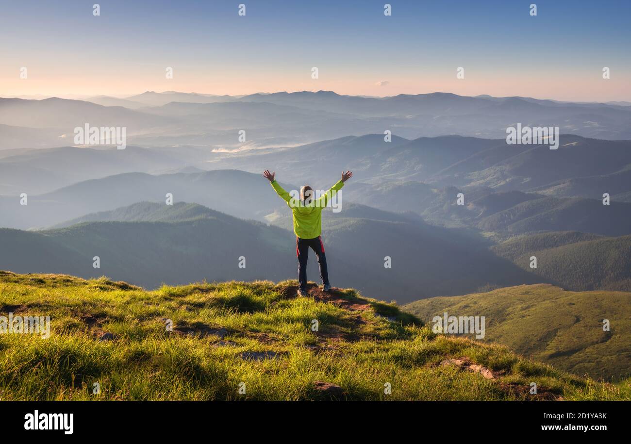Man standing on top of mountain with arms raised hi-res stock ...