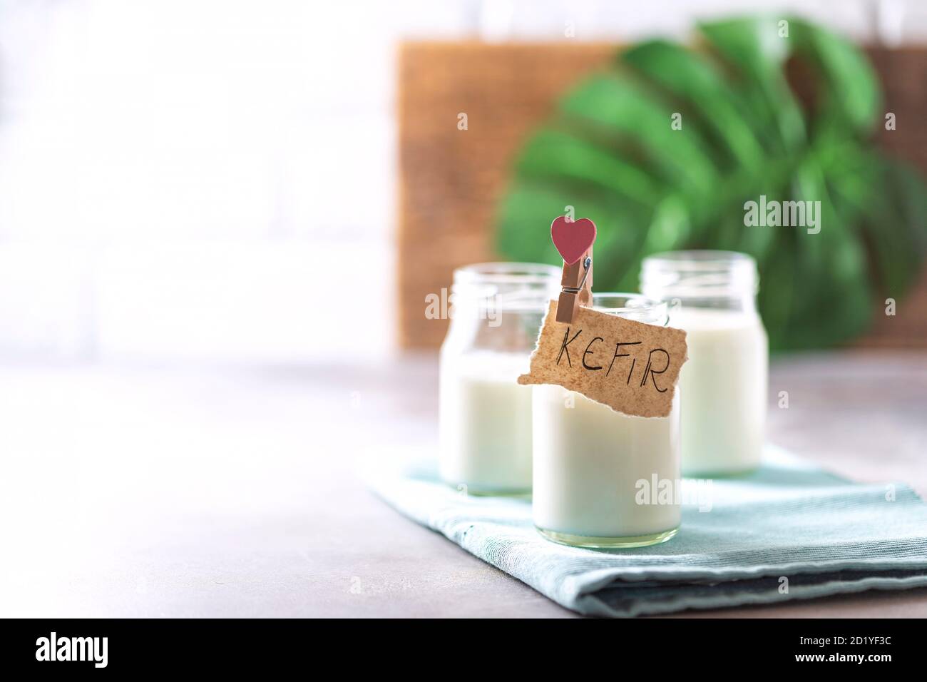 Fermented drink kefir in a glass jar on a light background. Probiotic ...