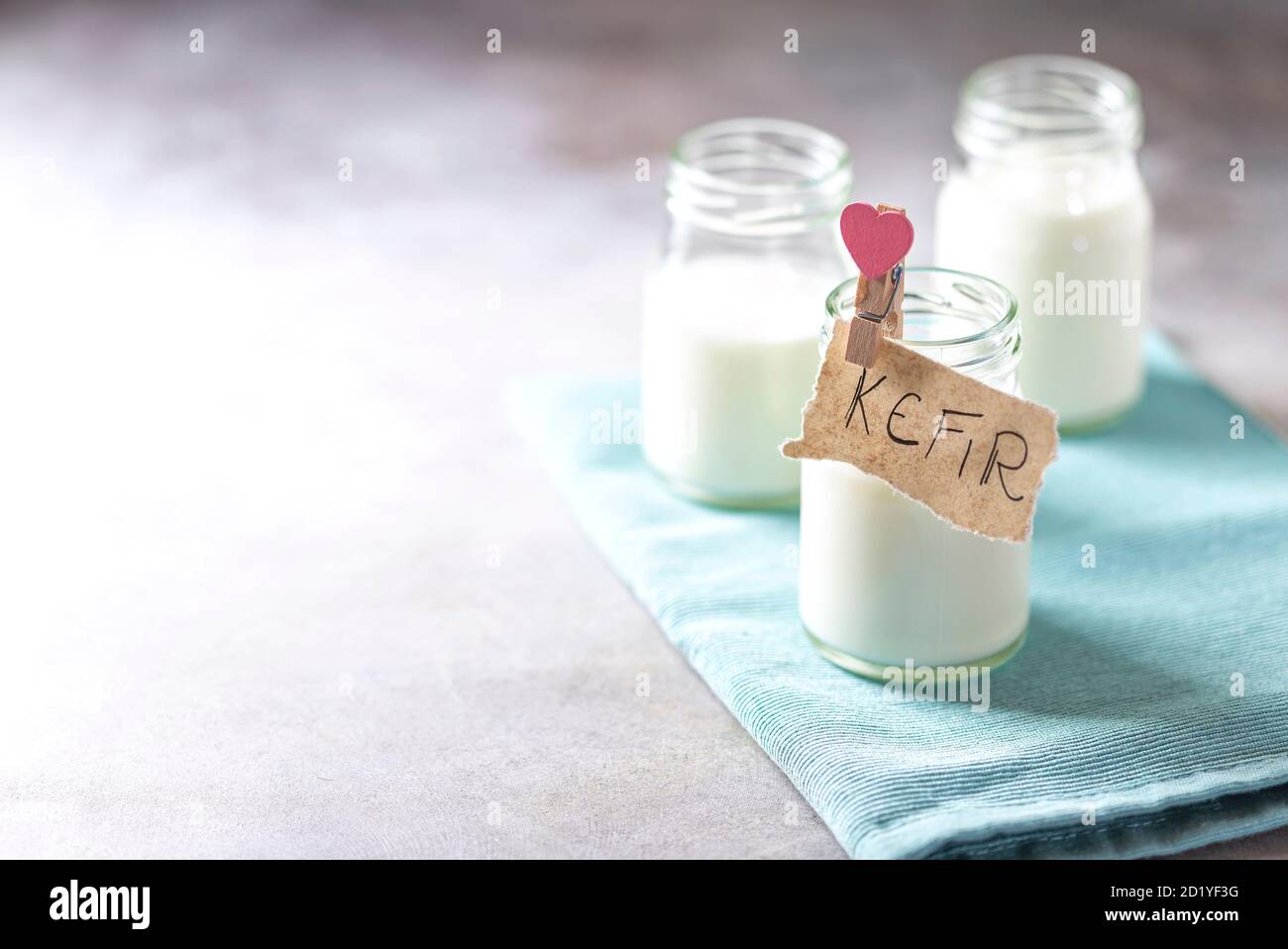 Fermented drink kefir in a glass jar on a light background. Probiotic ...