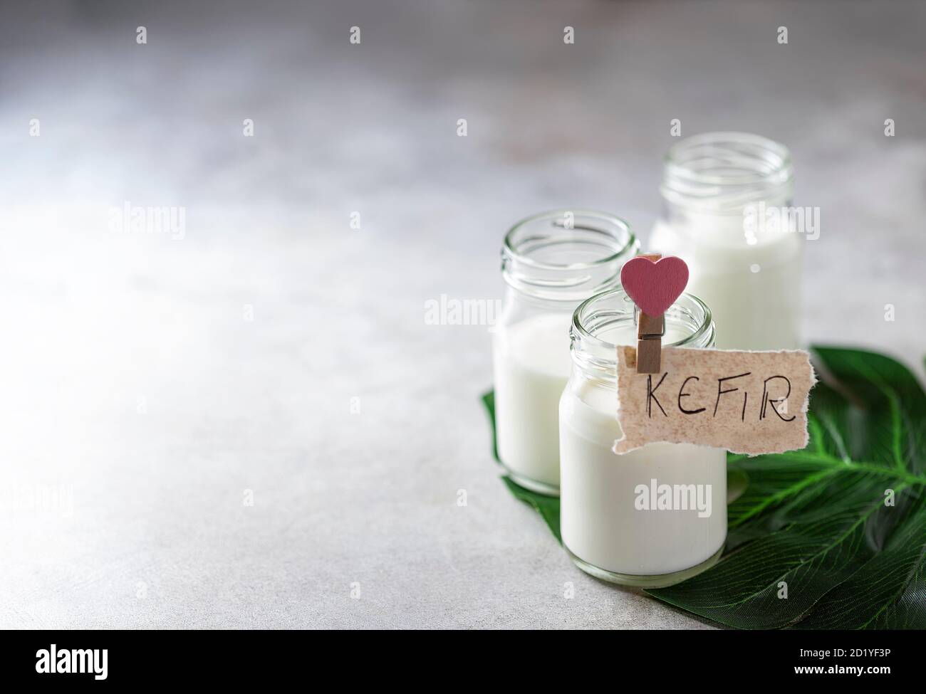 Fermented drink kefir in a glass jar on a light background. Probiotic ...