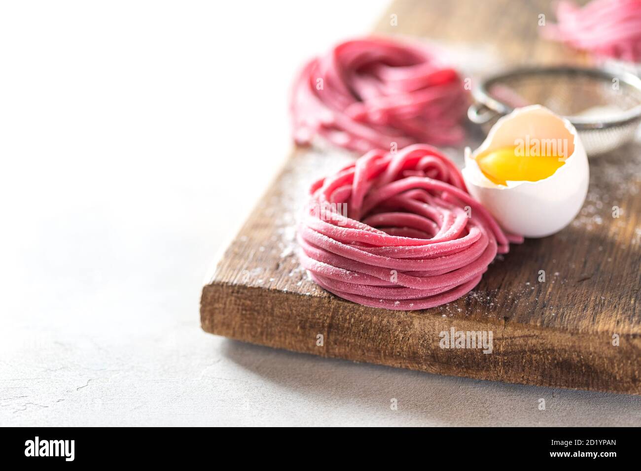 Fresh Hand made beetroot pasta on wooden cutting board. Raw purple ...