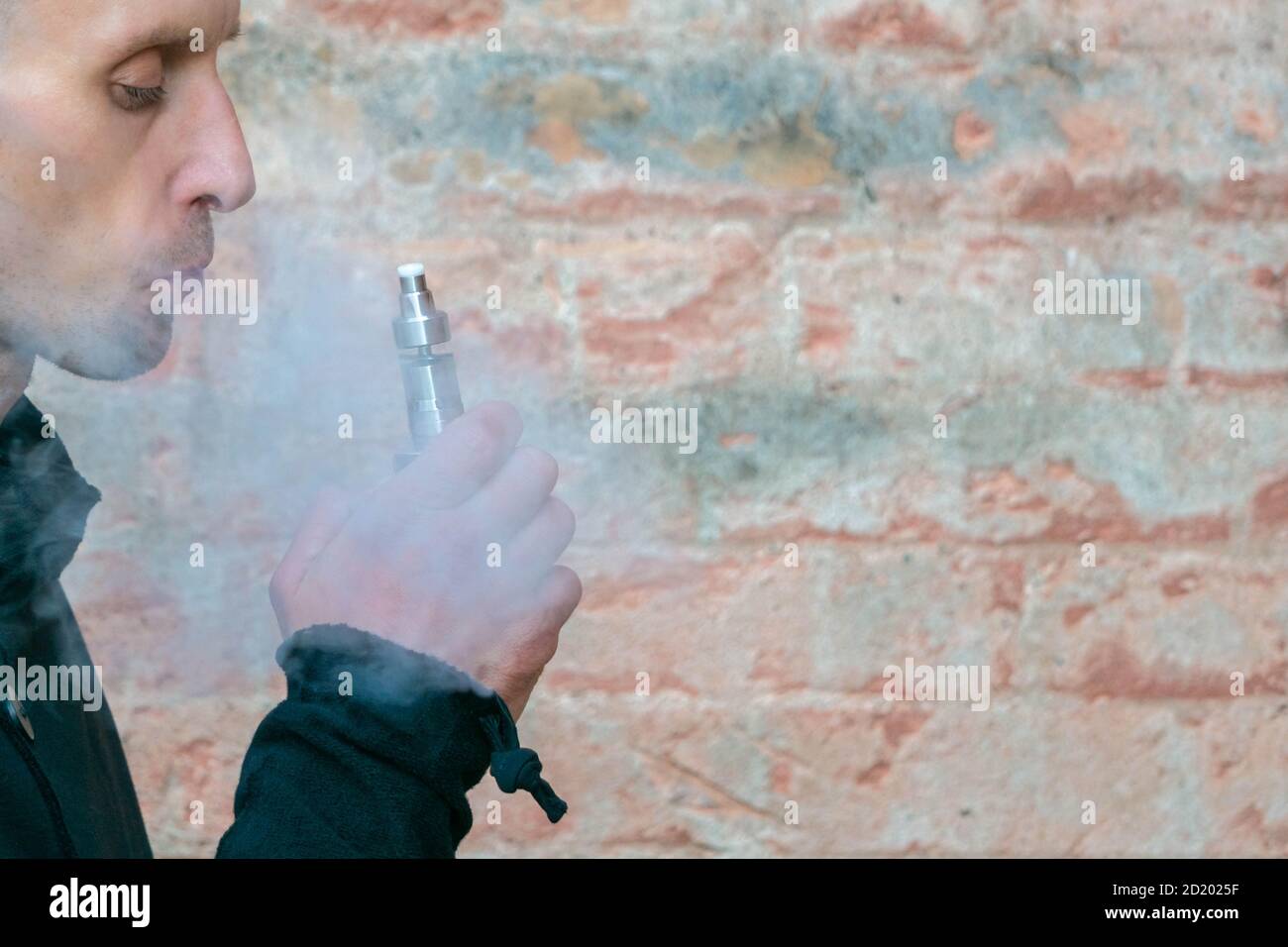 Vape man. Man with vaping mod exhaling steam of electronic cigarette ...