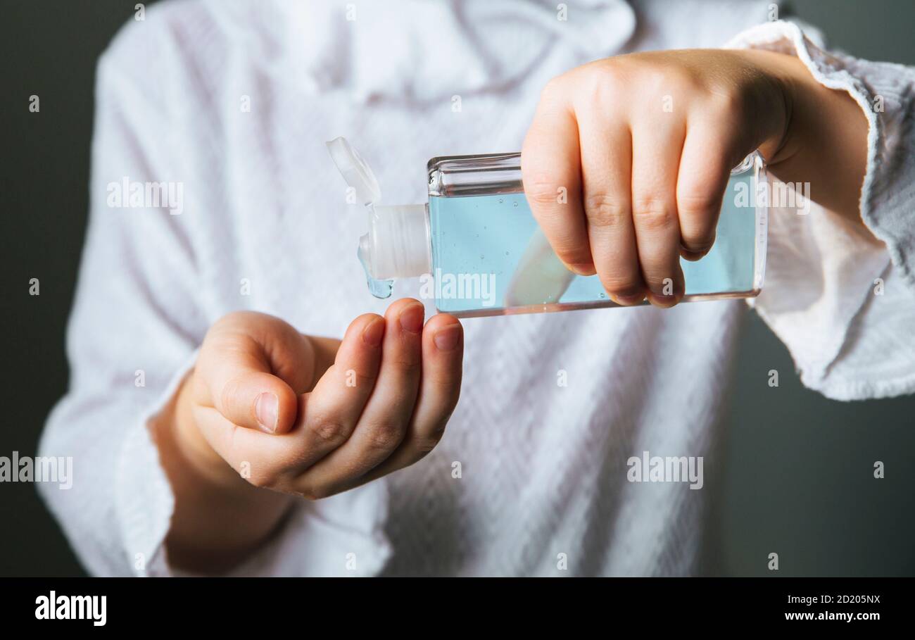 Close up view of 6 year old child using small portable antibacterial ...