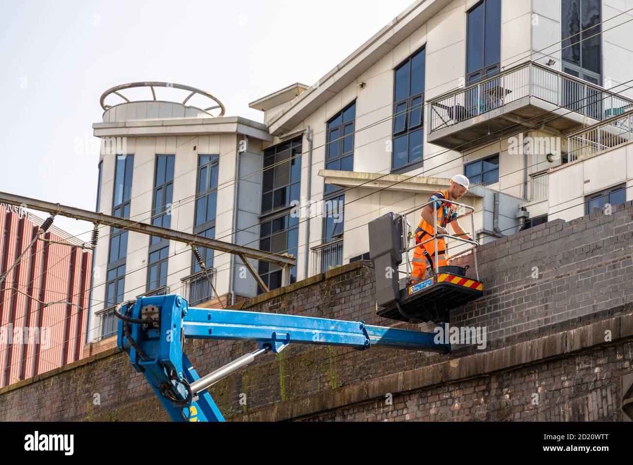 Bricklayer in standard safety uniform installing bricks and masonry ...