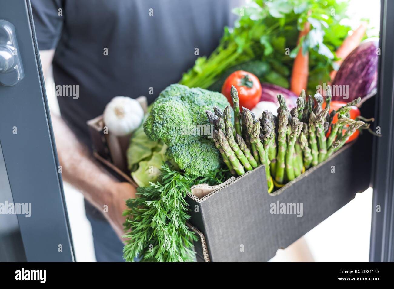 Fresh organic greens and vegetables delivery. Man hands holding box ...