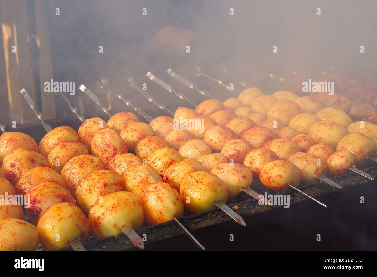 Potatoes on the grill. Cooking street food. Potato tubers are fried ...